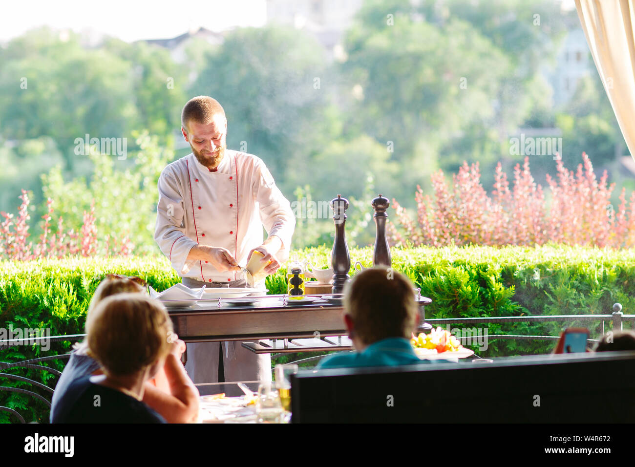 A man cook cuts meat with a knife in a restaurant Stock Photo - Alamy