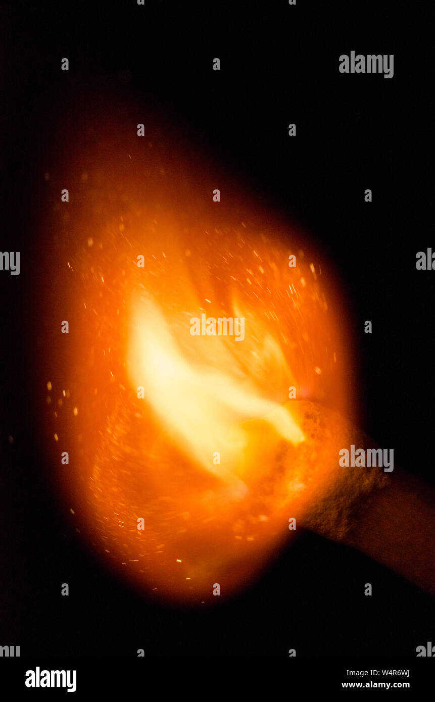 Ignition of matchstick with flames against dark background, still life ...