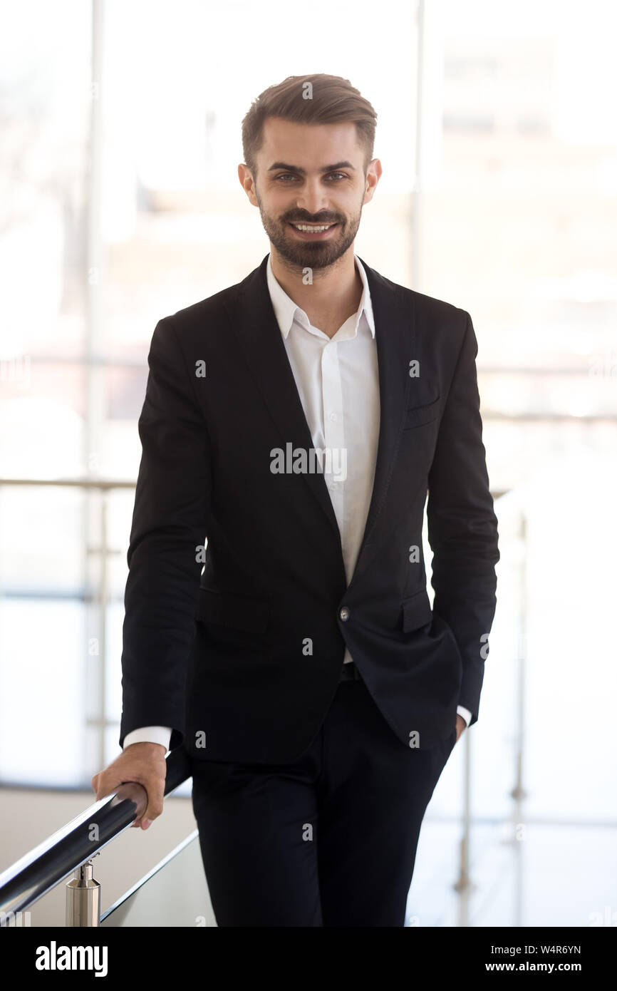 Vertical portrait of smiling businessman looking at camera in office ...