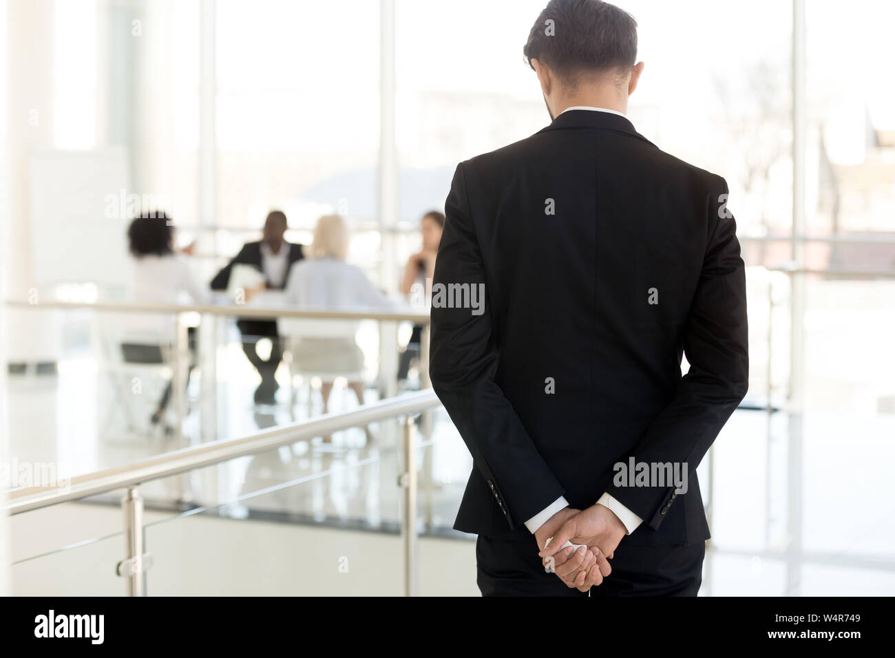 Nervous businessman waiting to enter at business meeting rear view ...