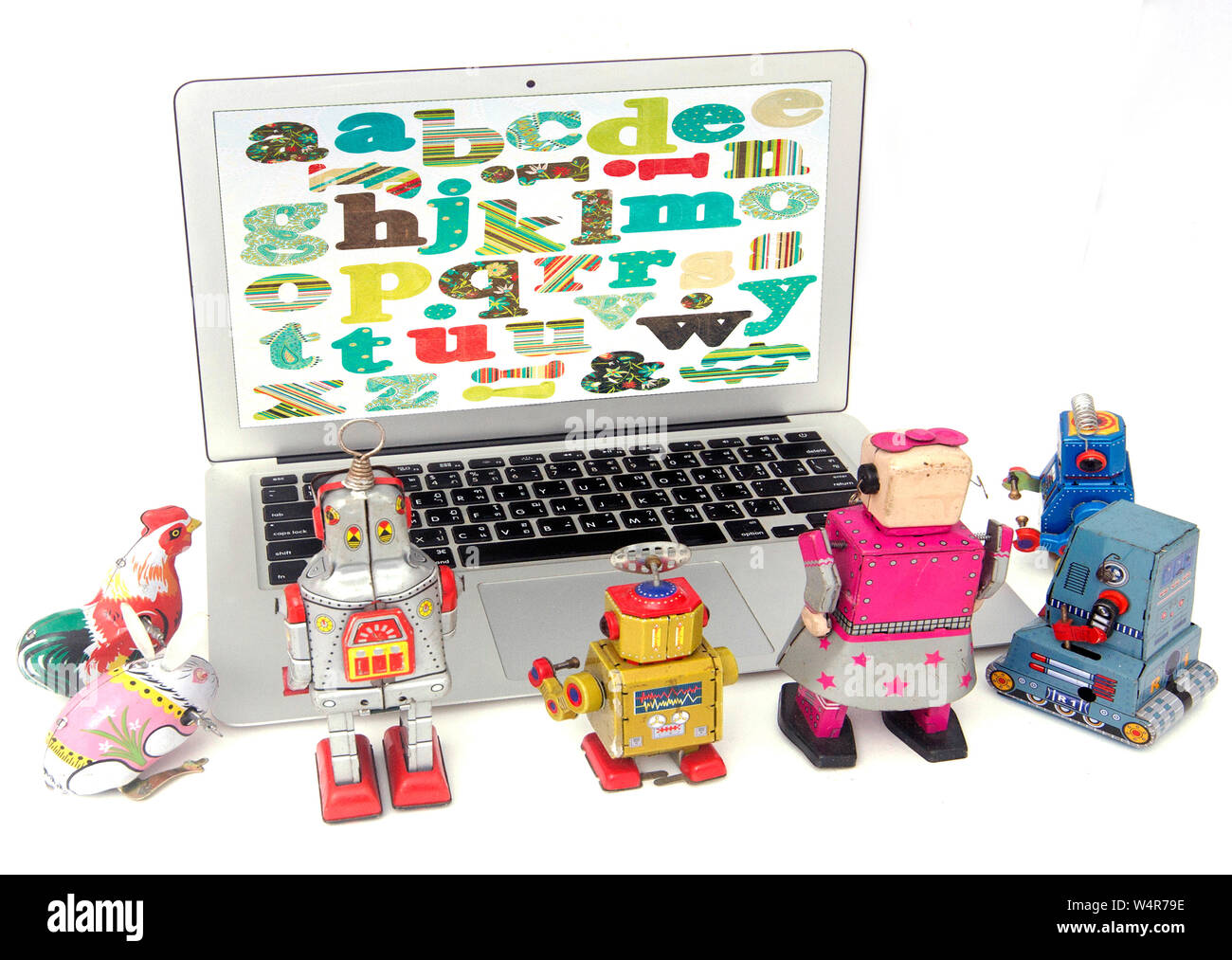 retro tin toys learning there alphabet on a laptop computer isolated on ...
