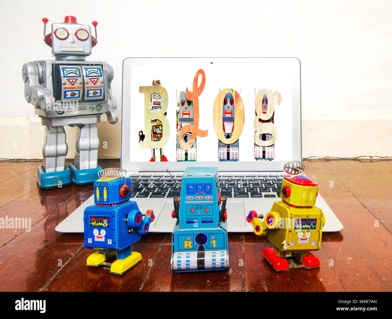 kid robots Blogging on a laptop on a lod wooden floor Stock Photo - Alamy