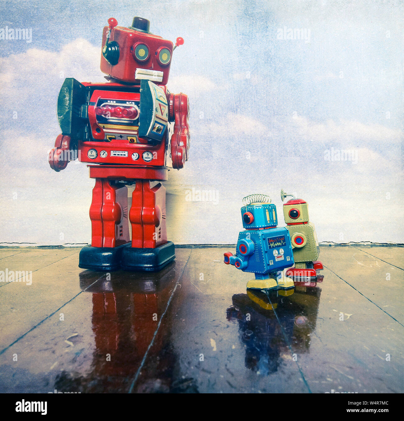 two little bots being reprimanded by the big red robot boss Stock Photo ...