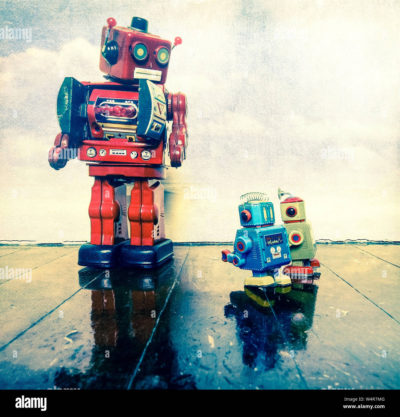 two little bots being reprimanded by the big red robot boss Stock Photo ...