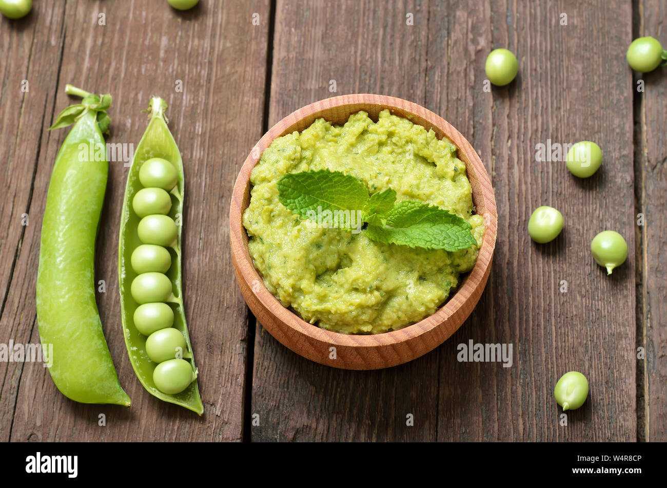 Green pea puree in wooden bowl, close up view Stock Photo - Alamy