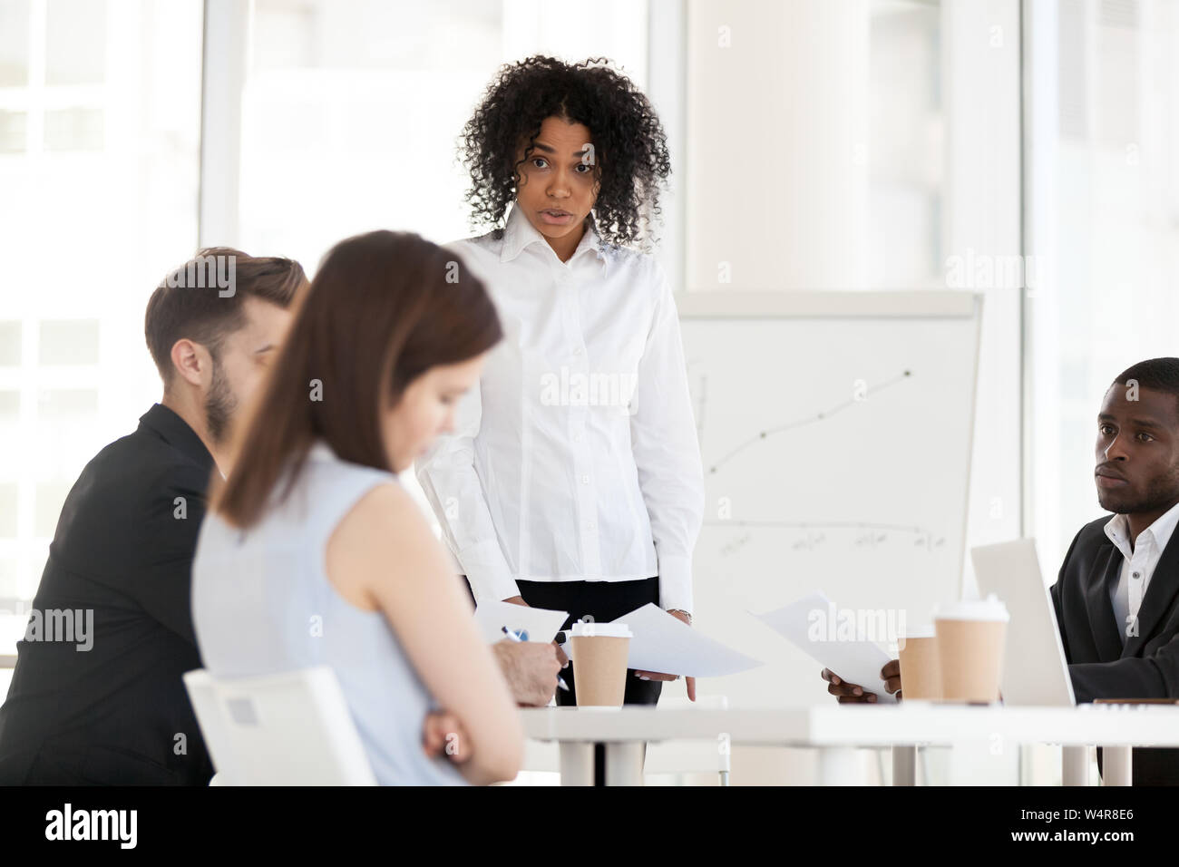 Angry African American businesswoman scolding employee for bad work ...