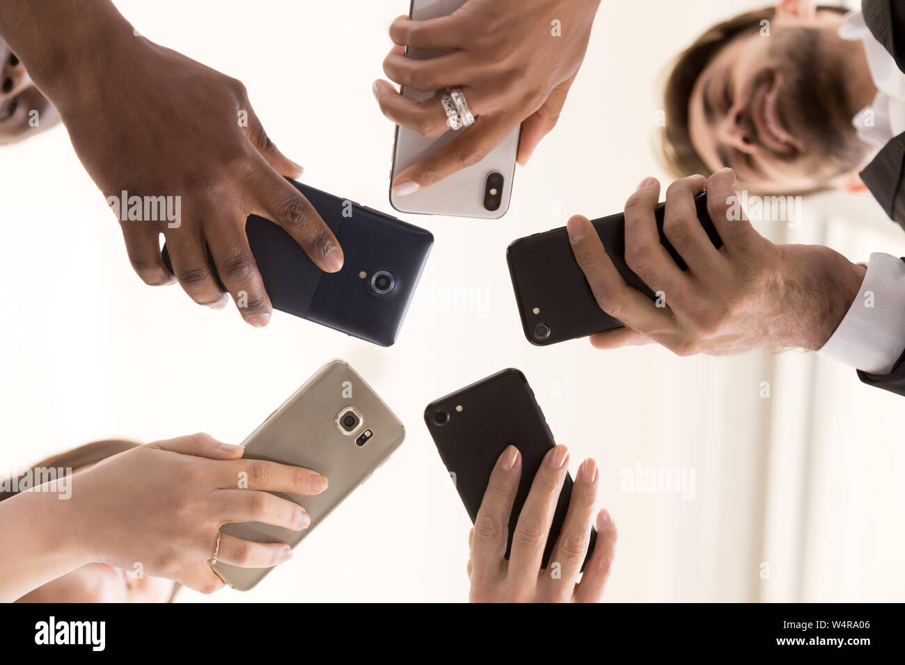 Diverse team employees using phones together bottom view Stock Photo ...