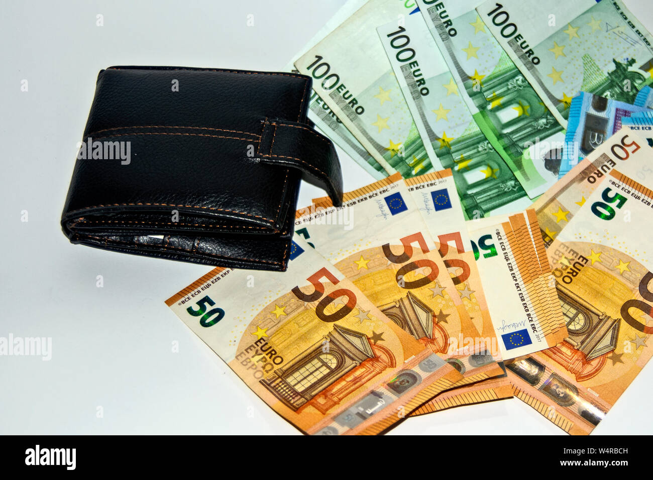 Wallet and cash paper bills in a pile on the table for investment Stock ...