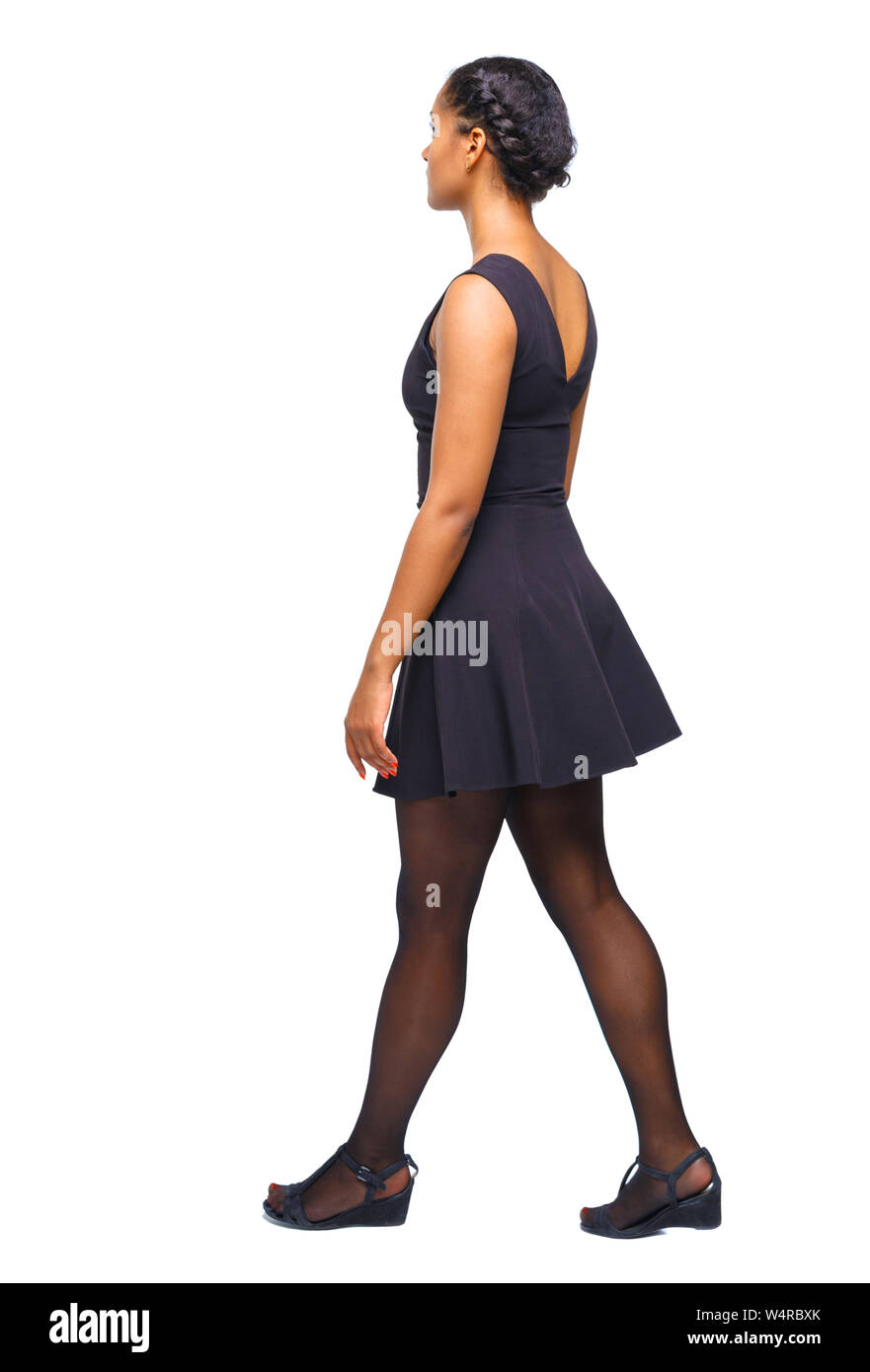 back view of a young black girl walking in jeans and a checkered shirt ...