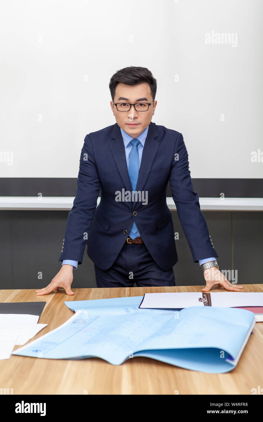 Man standing behind desk, Beijing, China Stock Photo - Alamy