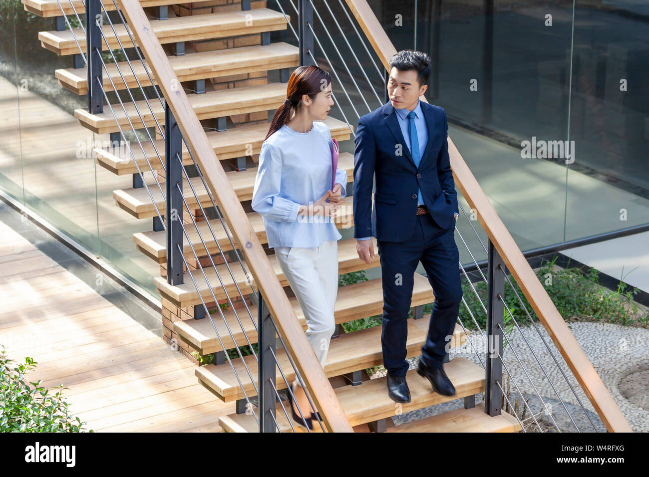 Manager and secretary walking down stairs, Beijing, China Stock Photo ...