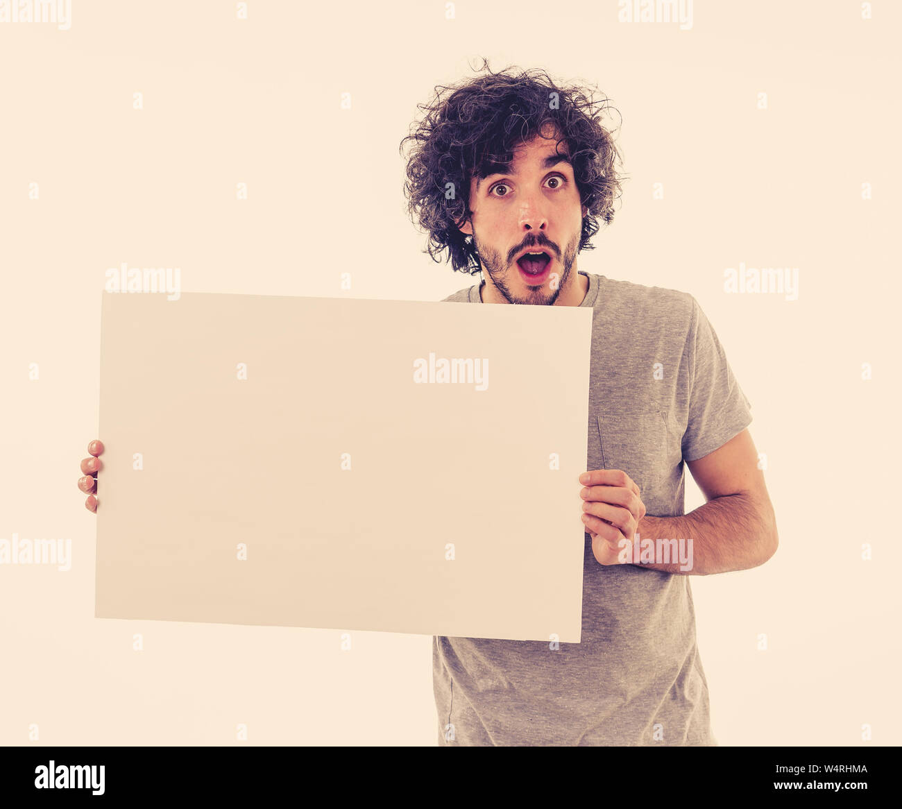 Funny and attractive millennial man showing blank poster with copy ...