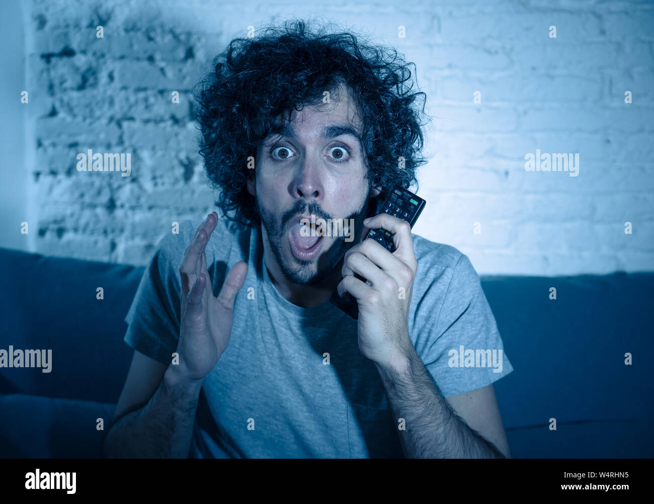 Lifestyle portrait of young disgust man watching horror movie or ...