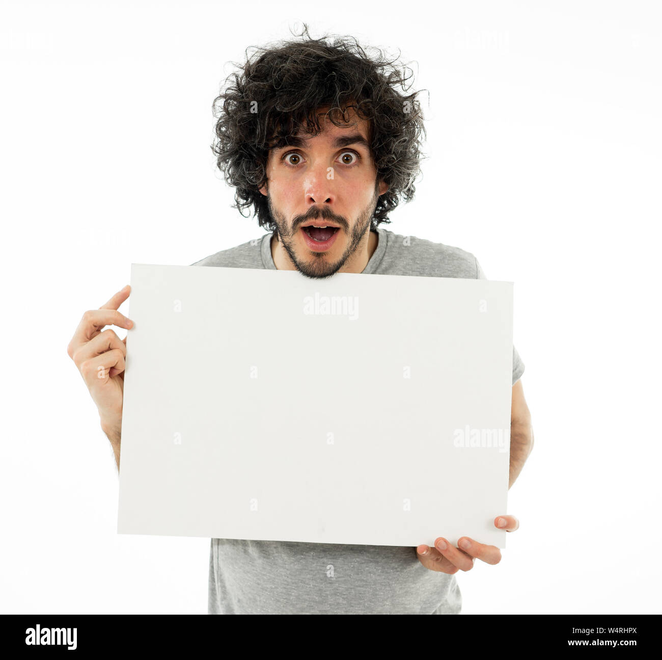 Funny and attractive millennial man showing blank poster with copy ...