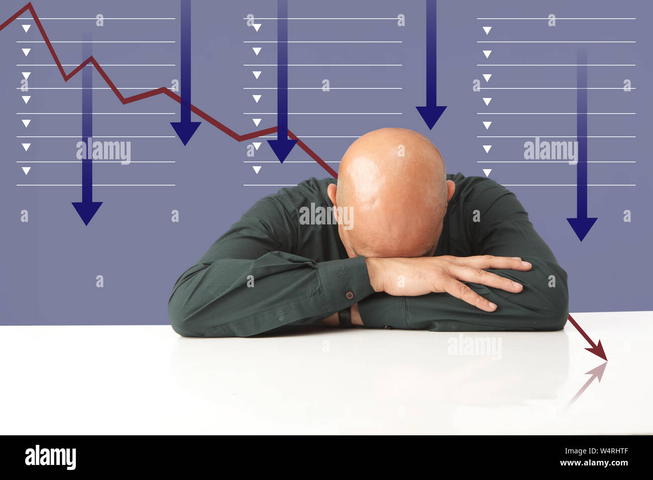 Depressed businessman with his face down in front of line graph moving ...