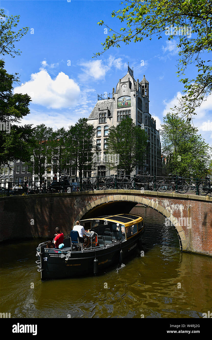 Tourboat passing under bridge, Amsterdam, Netherlands Stock Photo - Alamy