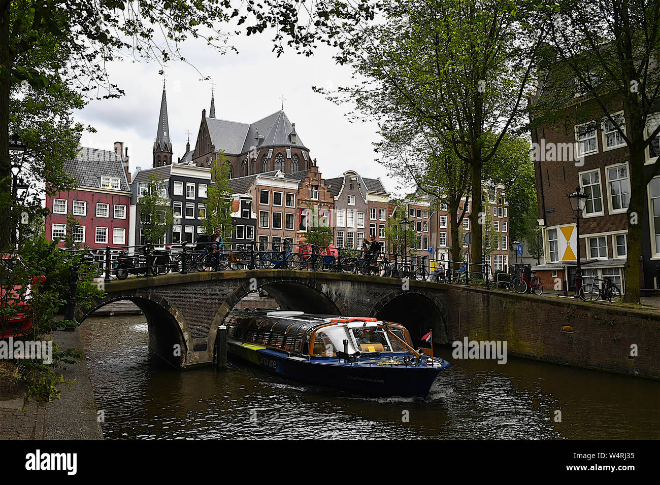 Tourboat passing under bridge, Amsterdam, Netherlands Stock Photo - Alamy