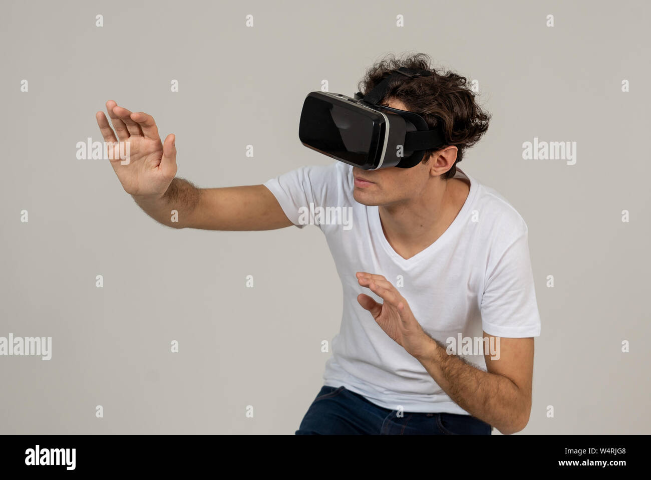 Amazed funny man using VR headset glasses touching and interacting with ...