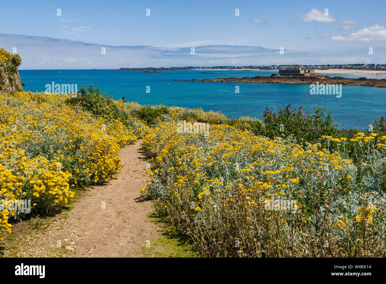 At low tide, tourists walk to the island of Grand Be an island off ...