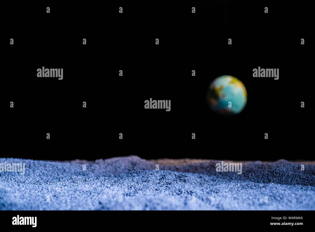 textured ground with blurred planet Earth in space isolated on black ...
