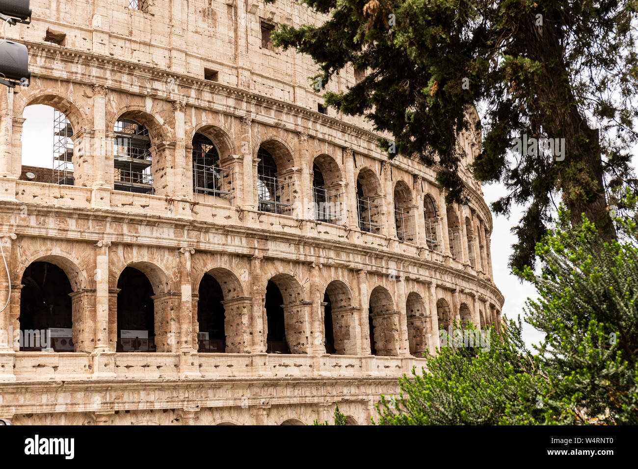 ROME, ITALY - JUNE 28, 2019: colosseum and green trees under grey sky ...