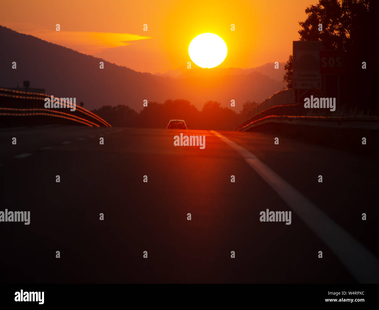 Over the hill. Motorway sunset, with holidaymaker cars returning from ...