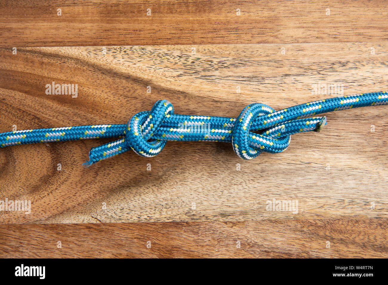 Fishing node on wooden background. Nautical rope knot Stock Photo - Alamy