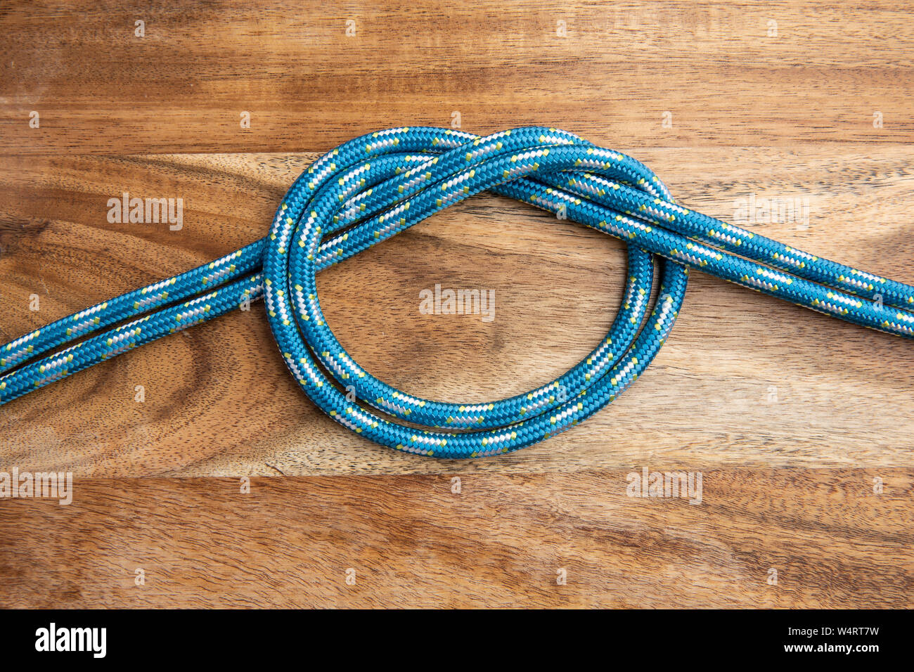 Overhand Bow Knot on wooden background. Rope node Stock Photo - Alamy
