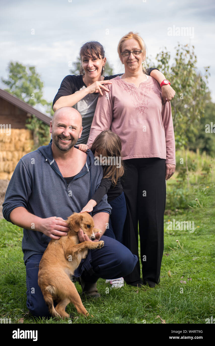 portrait of happy three generations family with dog at beautiful ...
