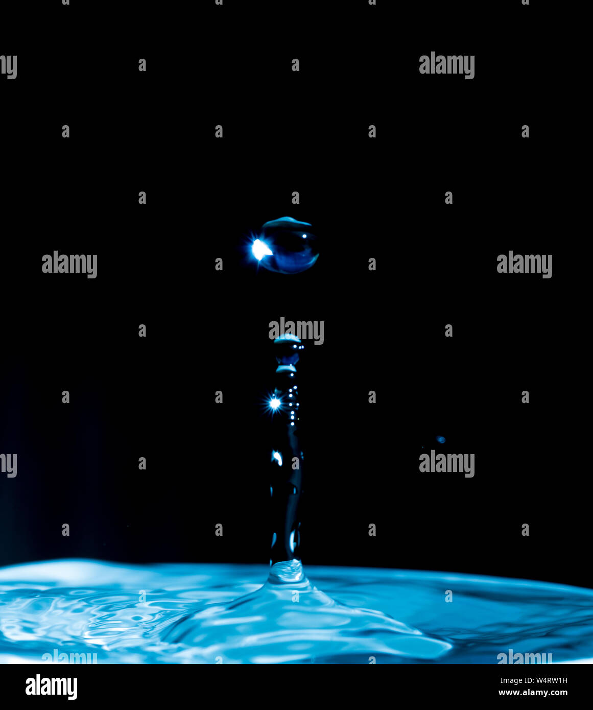 Bouncing water droplet on dark background Stock Photo - Alamy