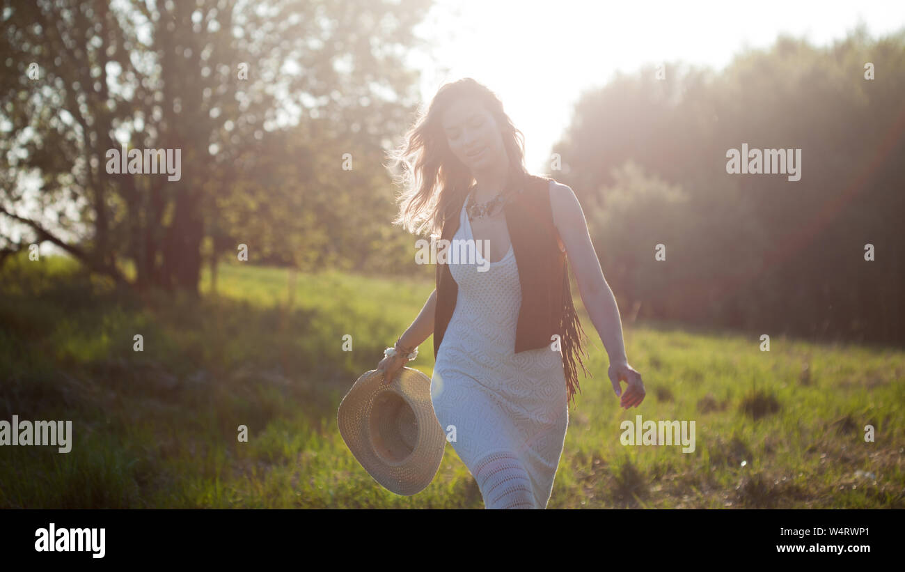 Cute charming girl in summer in the field. Young woman is happy and ...
