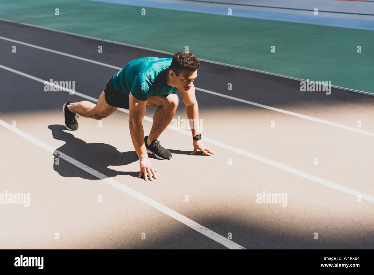 mixed race sportsman on start position at stadium Stock Photo - Alamy