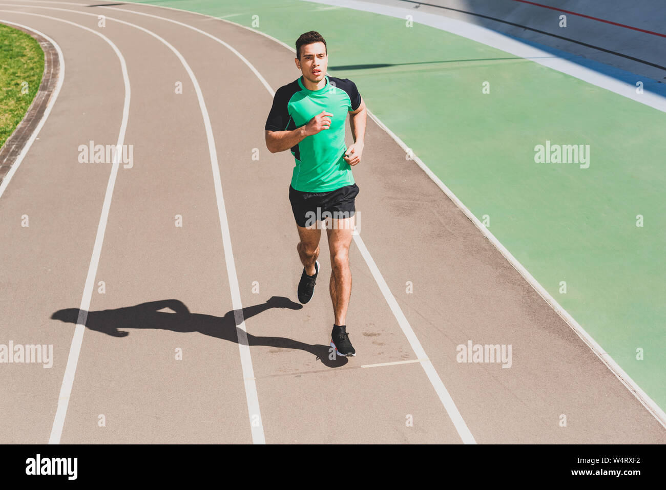 full length view of mixed race sportsman running at stadium Stock Photo ...