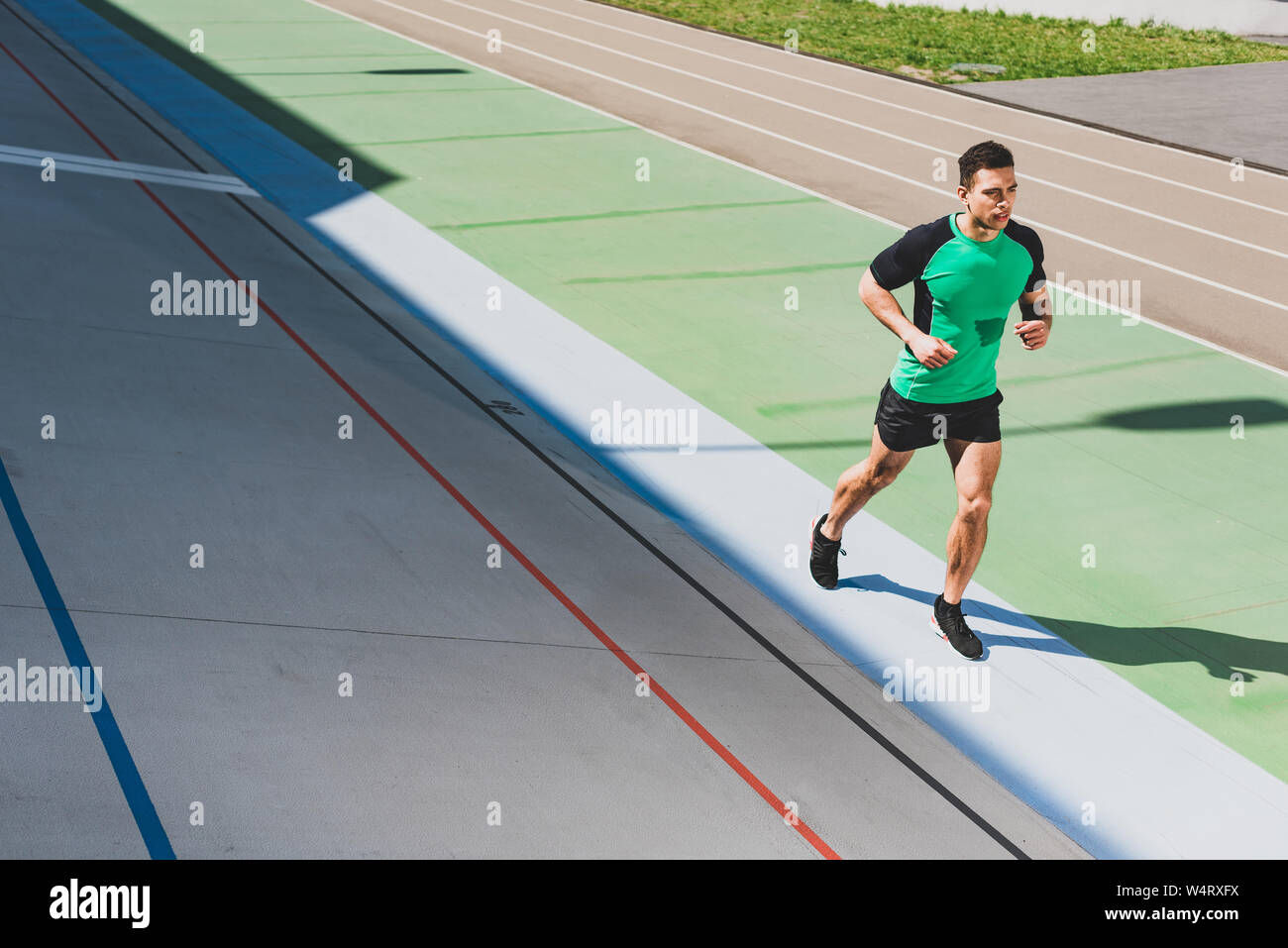 full length view of mixed race sportsman running at stadium Stock Photo ...
