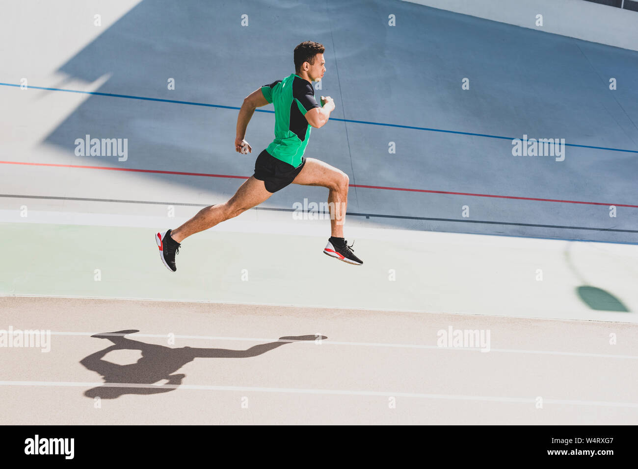 full length view of mixed race sportsman running at stadium Stock Photo ...