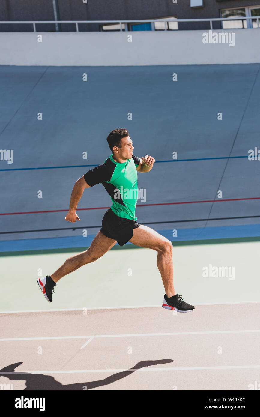 full length view of mixed race sportsman running at stadium Stock Photo ...