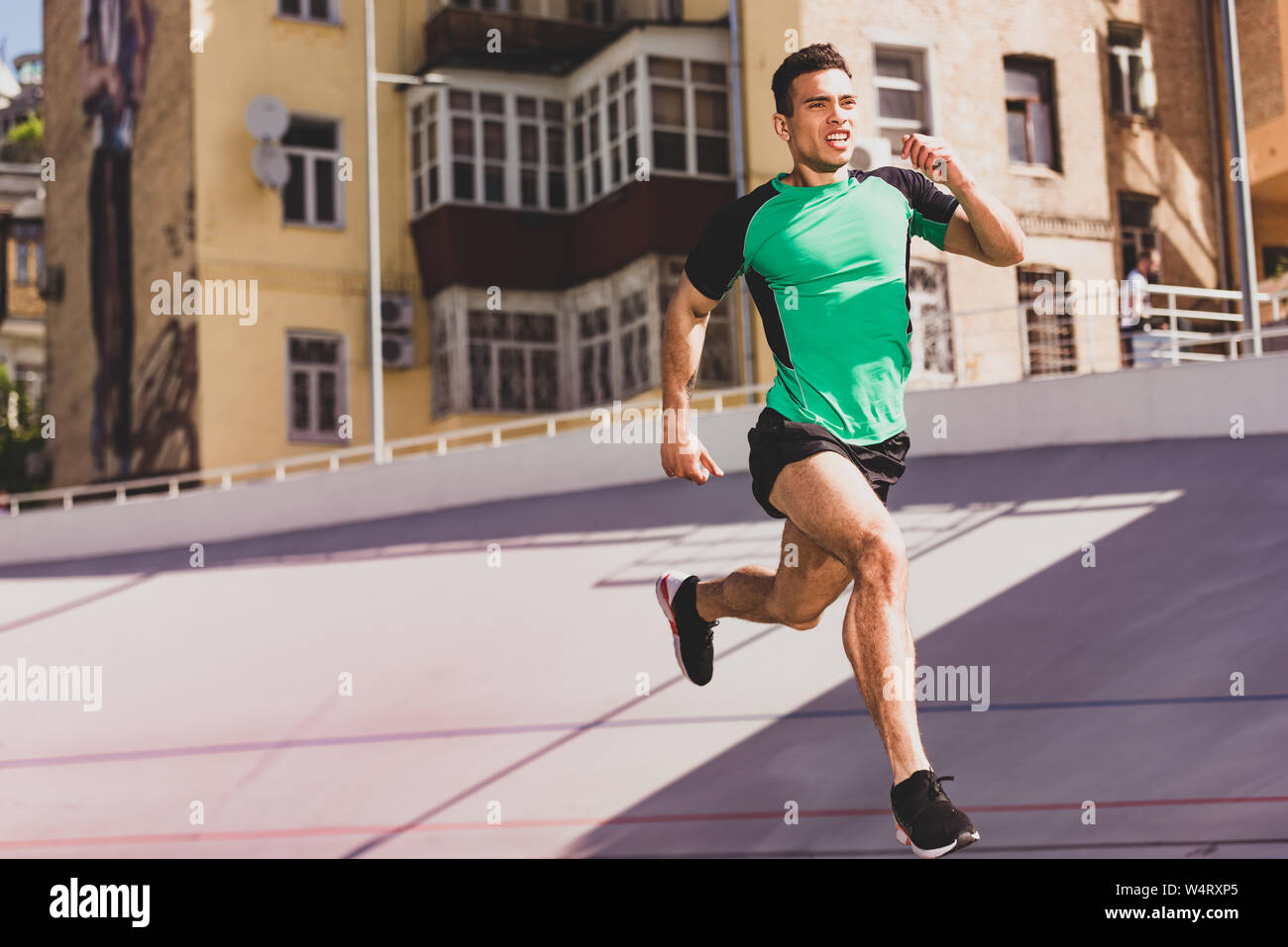 full length view of mixed race sportsman running at stadium Stock Photo ...