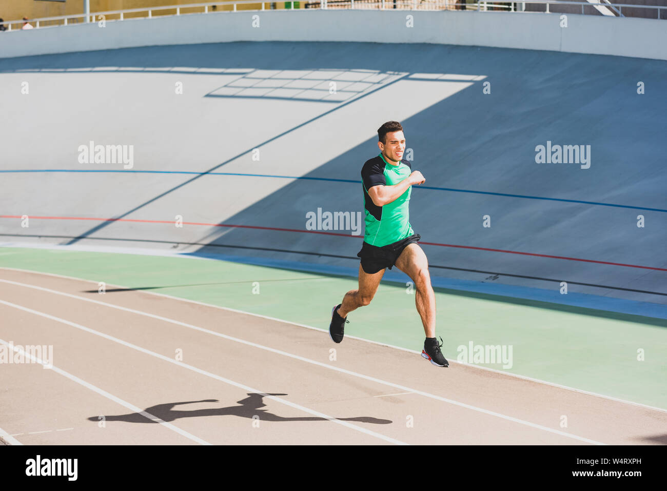 full length view of mixed race sportsman running at stadium Stock Photo ...