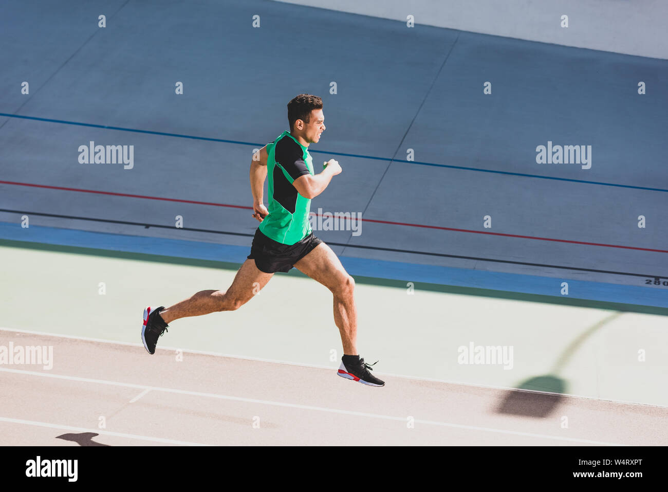 full length view of mixed race sportsman running at stadium Stock Photo ...