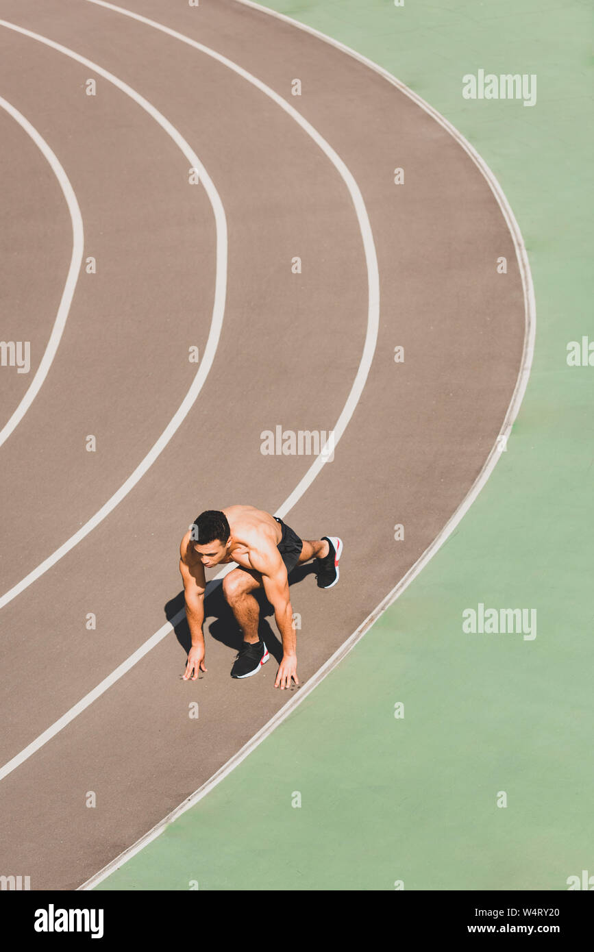 overhead view mixed race sportsman preparing to run at stadium Stock ...