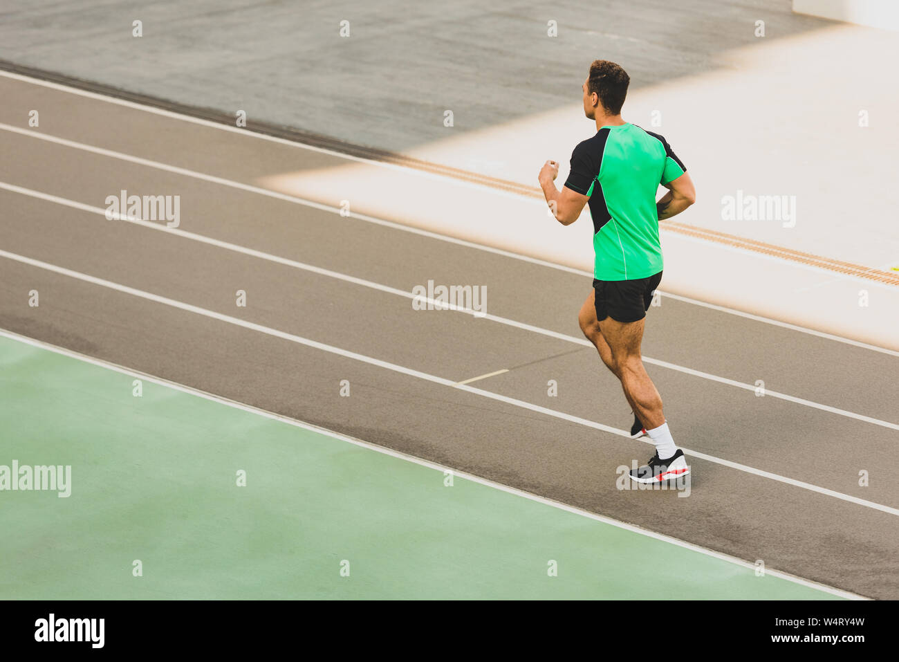 full length view of mixed race sportsman running at stadium Stock Photo ...
