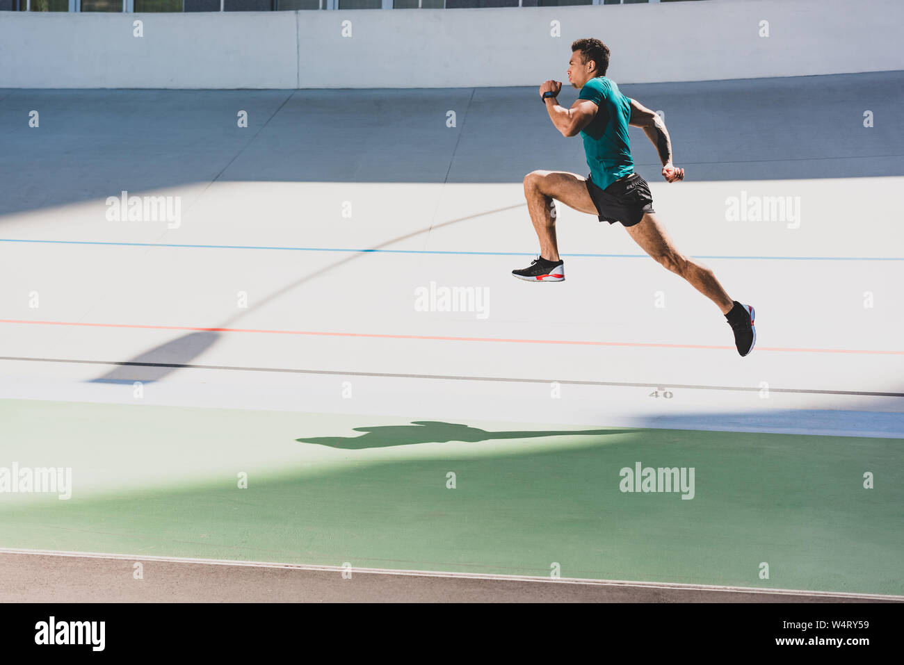 side view of mixed race sportsman running at stadium Stock Photo - Alamy