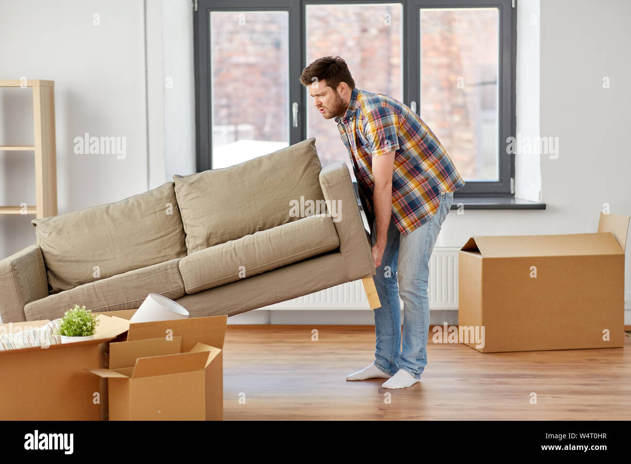man moving sofa at new home Stock Photo - Alamy