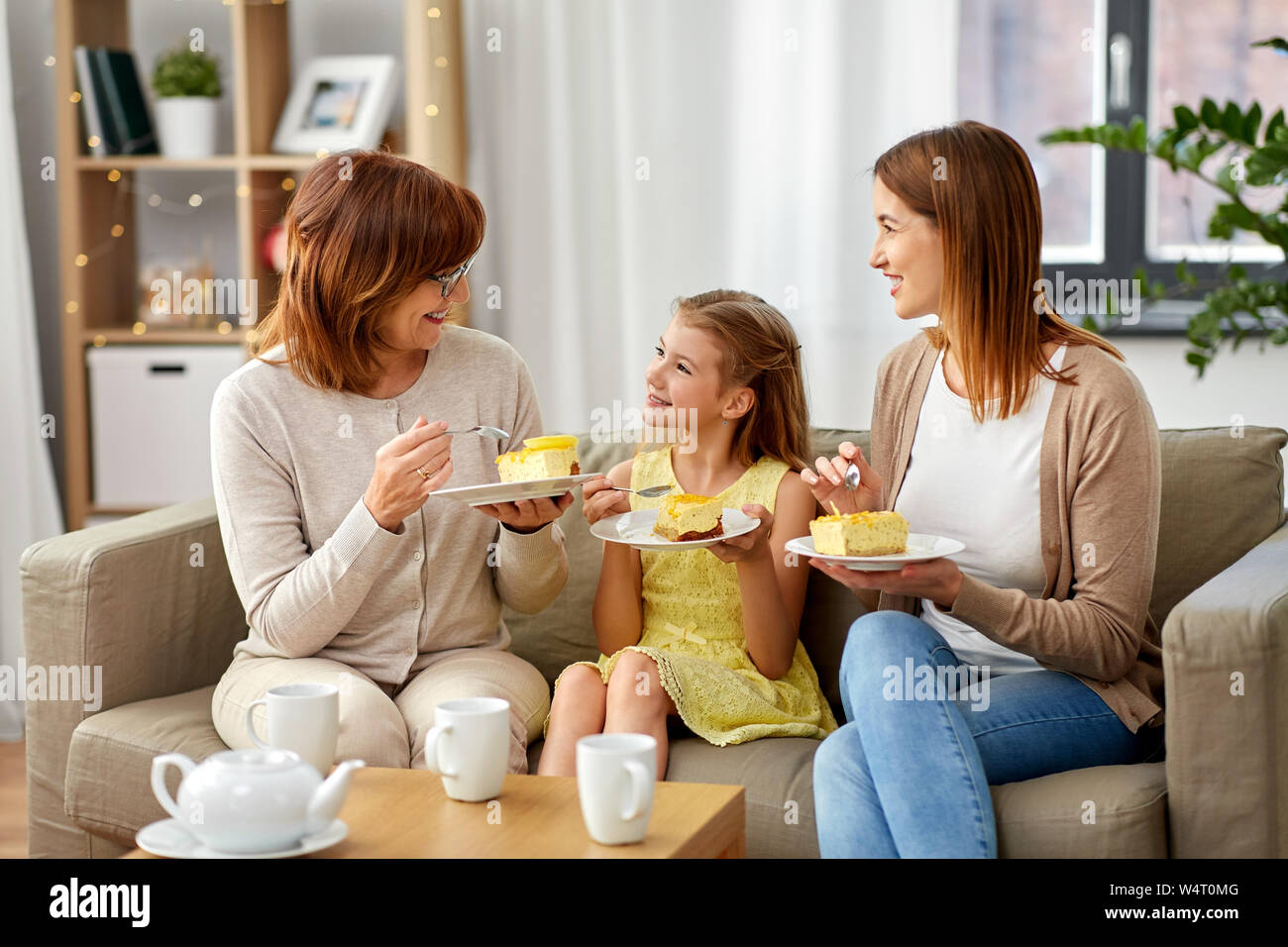 mother, daughter and grandmother eating cake Stock Photo - Alamy