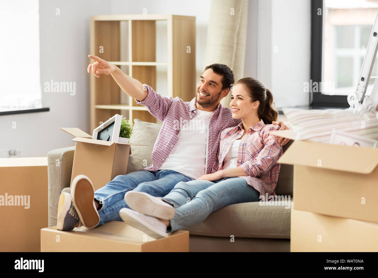 happy couple with boxes moving to new home Stock Photo - Alamy