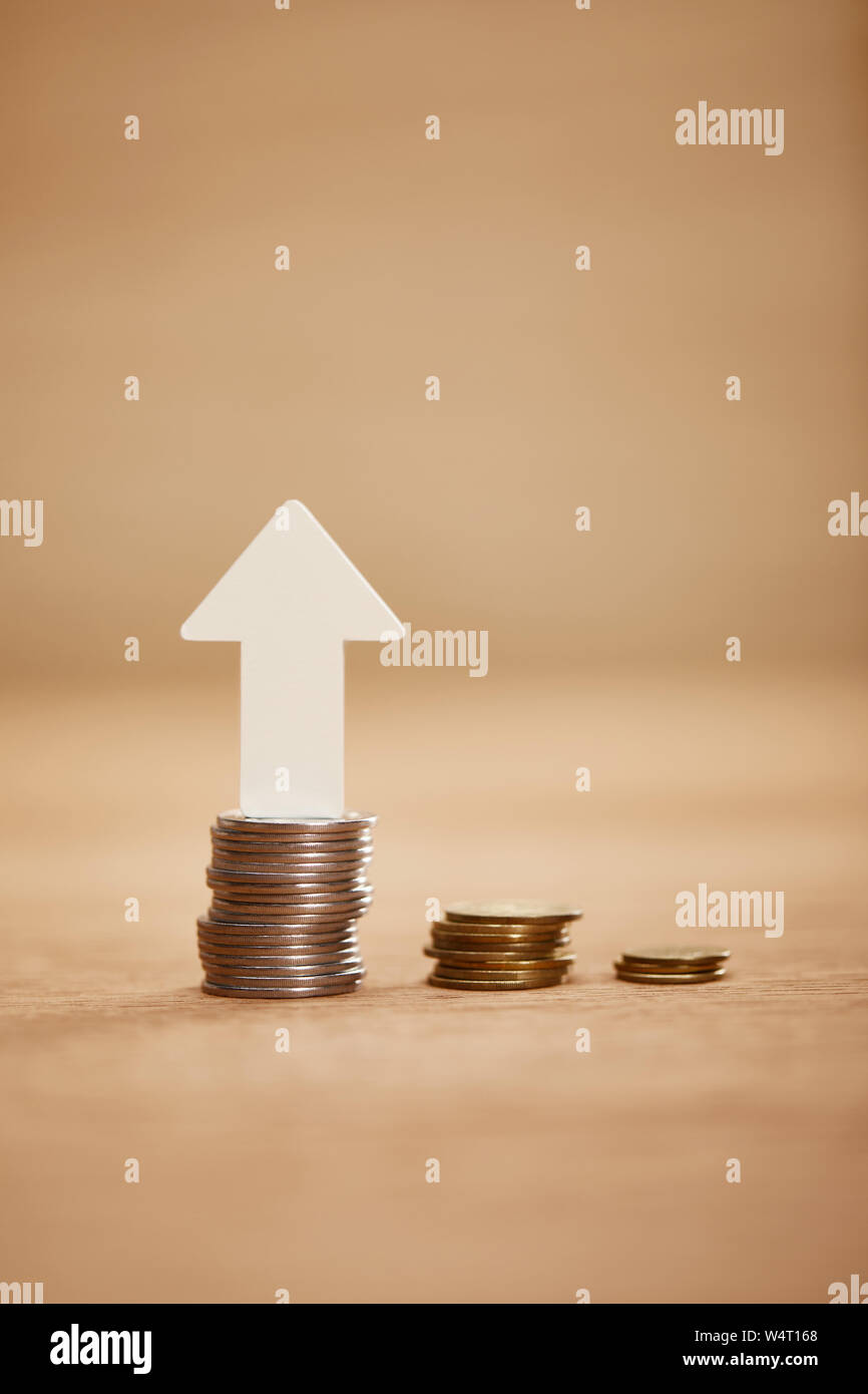increasing chart made of coins with white arrow upwards, financial ...