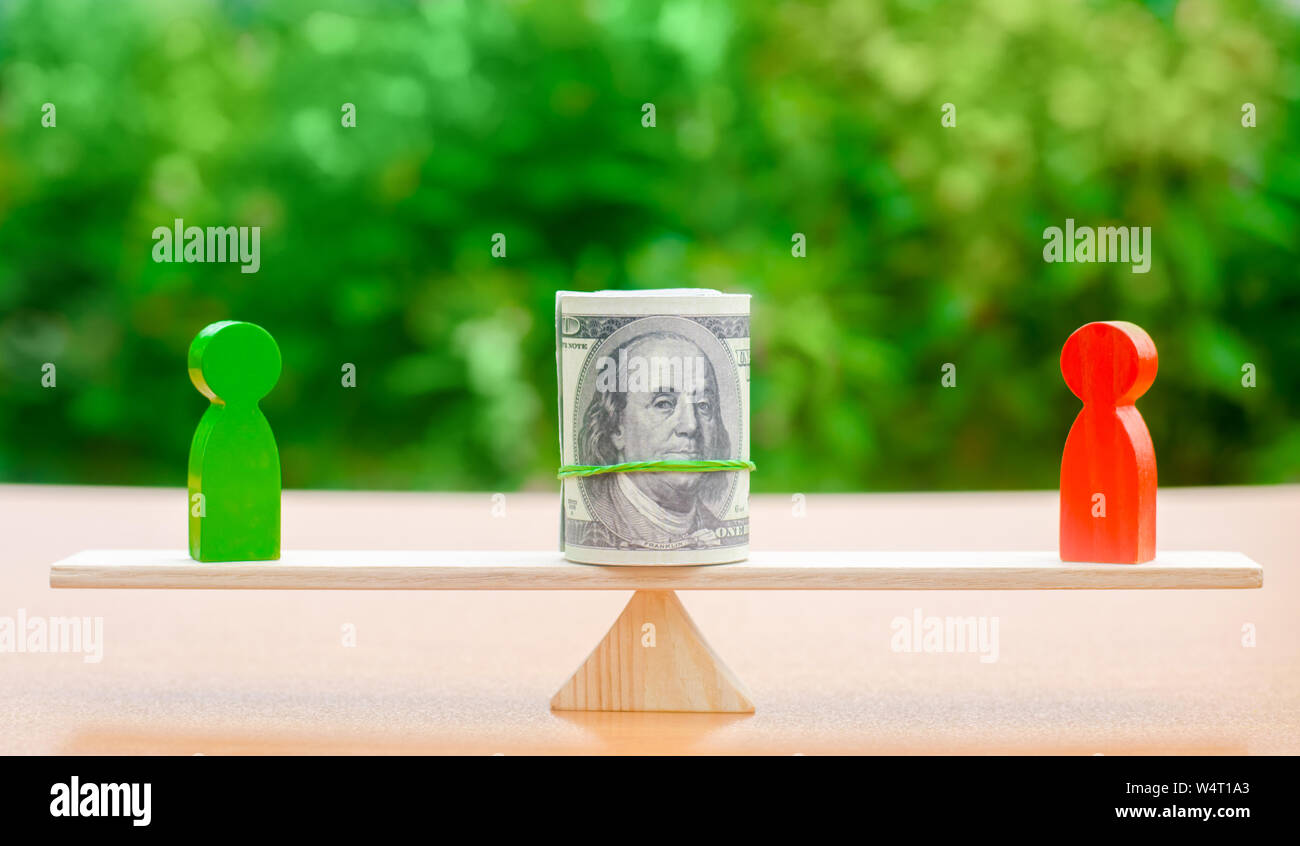 Wooden figures of people on scales and dollars banknotes between them ...