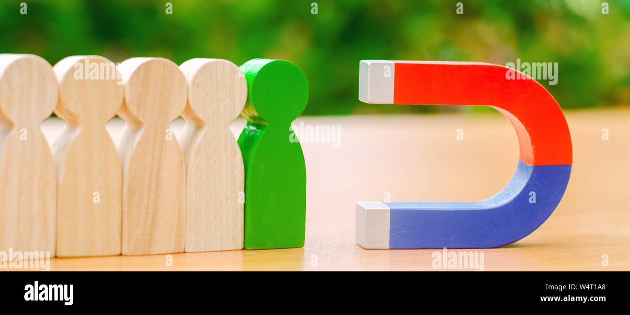 Wooden figures of people and a magnet. Team management concept. Human ...