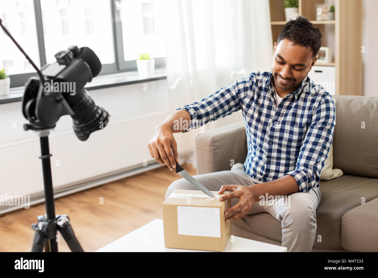 male video blogger opening parcel box at home Stock Photo - Alamy