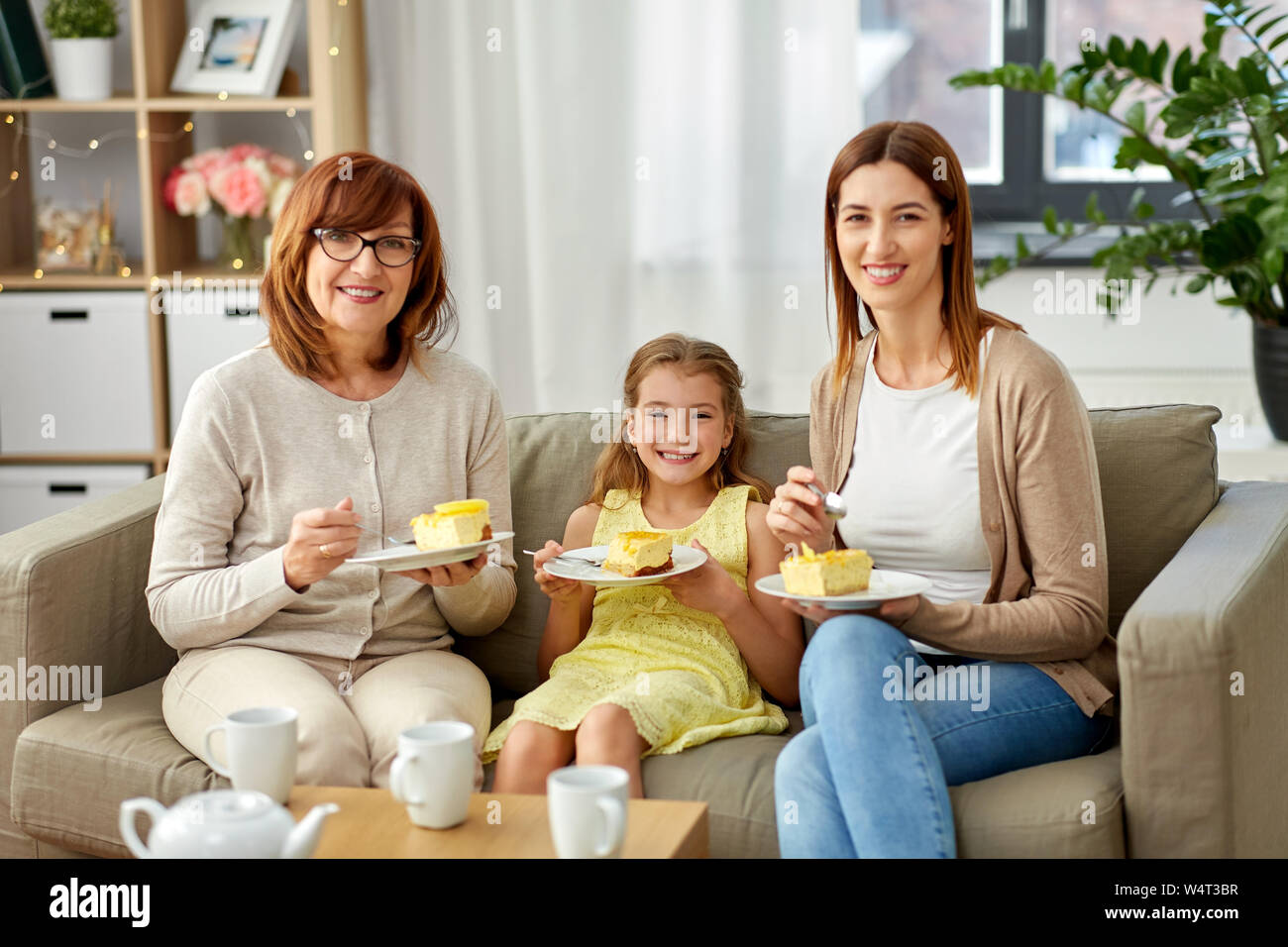 mother, daughter and grandmother eating cake Stock Photo - Alamy